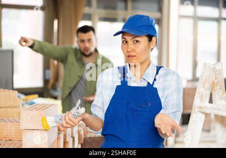 Confused female builder having conflict with construction manager Stock ...