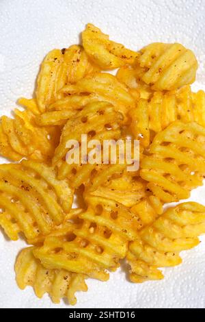 waffle criss cross fries, freshly fried, on kitchen paper towel ...