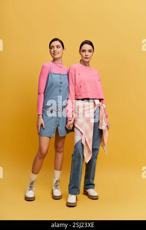 Portrait of two women against yellow background. They wear yellow and ...