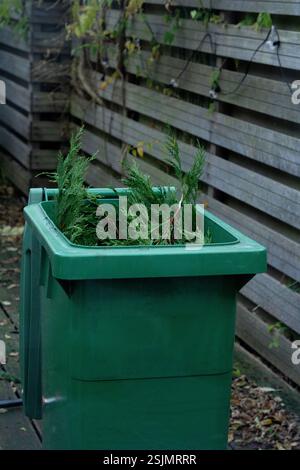 Three discarded green branches, forming a pile of natural waste, with ...