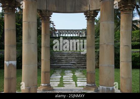 Cloisters, stone columns frame walkway lined with hedges. Gothic ...