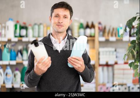 Middle-aged man choosing shampoo or shower gel in supermarket Stock ...