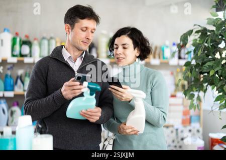 Man with wife uses barcode to get information about glass cleaner spray ...