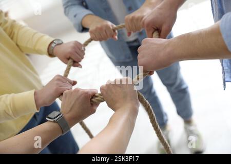 Unity concept. People holding rope together indoors, closeup Stock ...