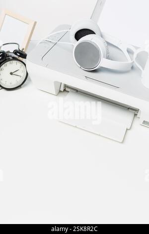 Desk setup featuring printer, clock, computer, and personal items in a ...