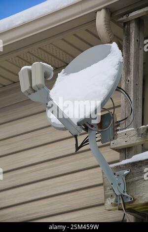 Snow builds up on an outside garden hose and reel during a Canadian ...