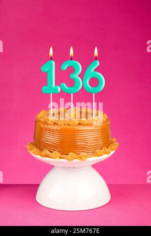 Number 136 - Burning anniversary candle on blue foamy background Stock ...