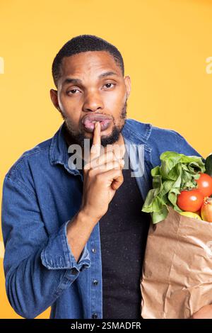 Portrait of excited man asking to keep quiet, showing hush taboo sign ...