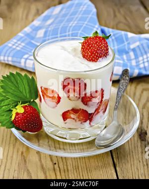 Strawberries in a saucer on a wooden background Stock Photo - Alamy