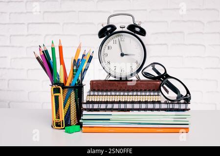 Pencils holder, markers, notebooks and clock on wooden background Stock ...