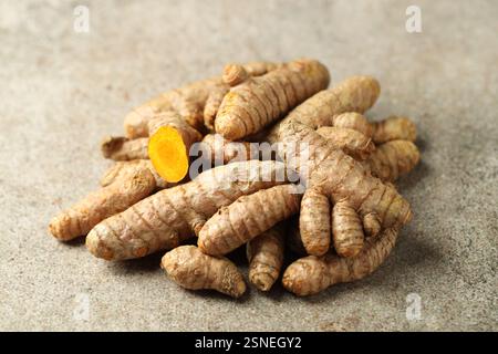 Pile of tumeric rhizomes on grey table, top view. Space for text Stock ...