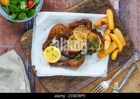 Roasted spatchcock poussin with potato chips Stock Photo - Alamy