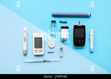 Modern glucometers with lancet pens and insulin ampule on color ...