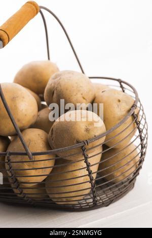 Uncooked potatoes in wire basket Stock Photo - Alamy