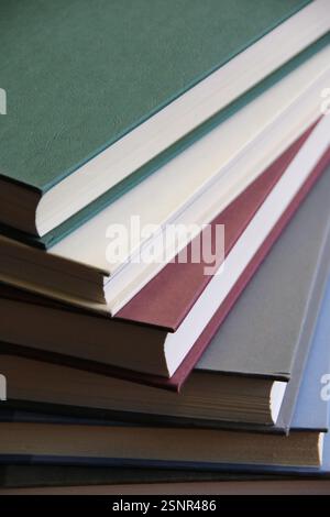 Hardback books stacked in a stair step manner Stock Photo - Alamy