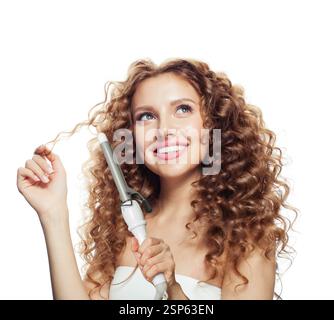 The female hairdresser is curling hair for a brown-haired young ...