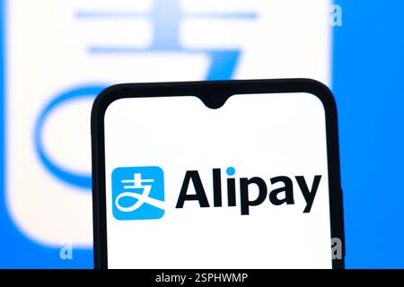 In this photo illustration, Alipay logo is seen on a smartphone and a ...