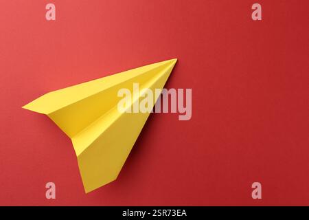 Yellow paper plane on red background Stock Photo - Alamy