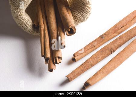 Spices, cinnamon in jute sack spread on white background Stock Photo ...
