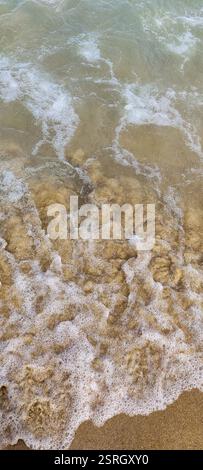 Beautiful sandy beach with wave seafoam clashing on sandy shore ...