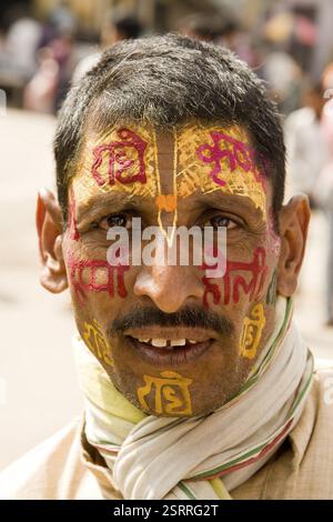 Devotee writing radhe krishna on face by sandalwood paste, uttar ...