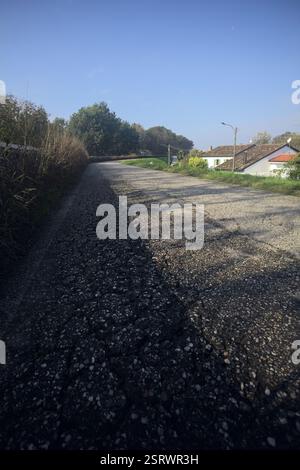 Country road over an embankment passing next to a village and a park on ...