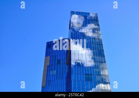 Enagas headquarters with clouds reflected on the glass façade, iconic ...