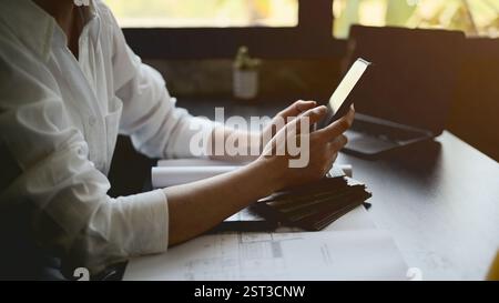 Cropped view of interior designer using smartphone and holding color ...