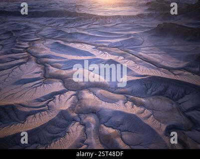 Aerial view of dramatic eroded desert landscape with deep jagged ridges ...
