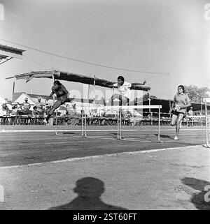 Running competition, South Asian Indian athlete performing Hurdles ...