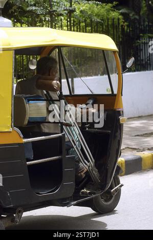 A physically handicapped rickshaw driver drives a auto rickshaw in ...