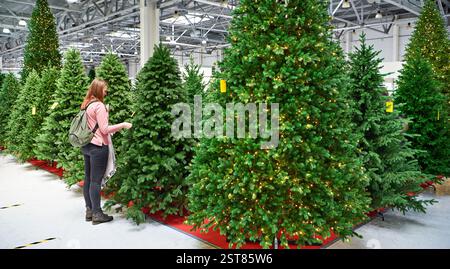 A girl chooses a christmas tree at a shop Stock Photo - Alamy