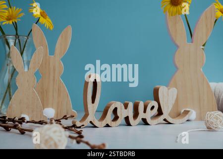 Wooden word LOVE with bunny figures eggs and fresh flowers. Easter ...