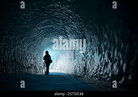 Human figure silhouette inside ice cave under glacier in Chamonix ...