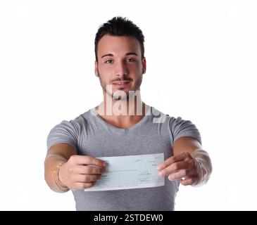 Young man showing check or cheque in his hands, looking at camera ...