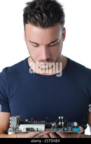 Confused, puzzled computer technician, a handsome young man, looking at ...