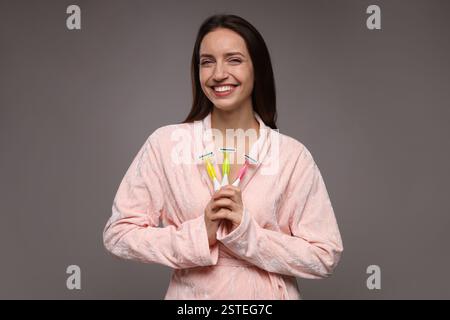 Happy woman with different razors on grey background. Hair removal ...