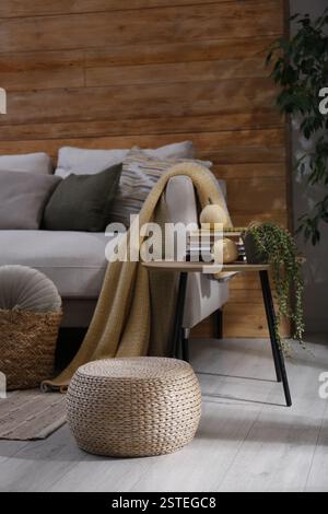 Comfortable sofa, table, pouf and autumn decor in interior of living ...