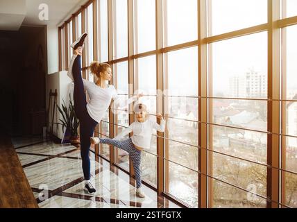 Mother learning daughter to make a high leg strech Stock Photo - Alamy