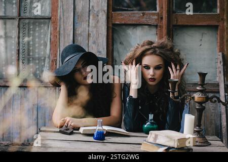 Two vintage witches perform magic ritual, with elixir in hand on the ...