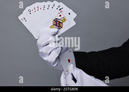 Illusionist hiding one playing card up his sleeve while showing deck on ...