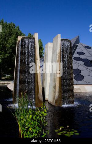 A cascading water feature with a futuristic pyramid structure in the ...