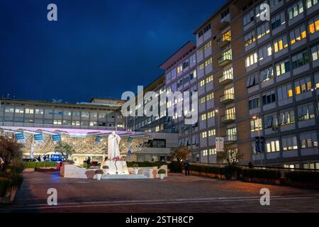 Rome, Italy. 18th Feb, 2025. A woman carries flowers under the statue ...