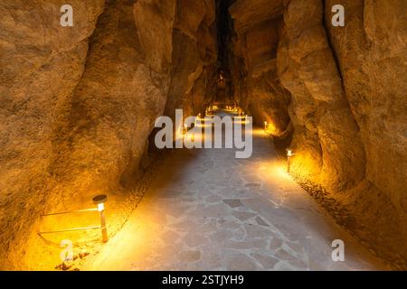 Warm lights illuminating sandstone walls inside Jabal Al Qarah Mountain ...