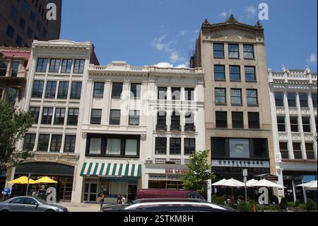 Facades of white buildings with green awnings and cars parked on the ...