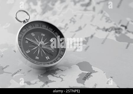 Compass on world map, toned in black-and-white Stock Photo - Alamy