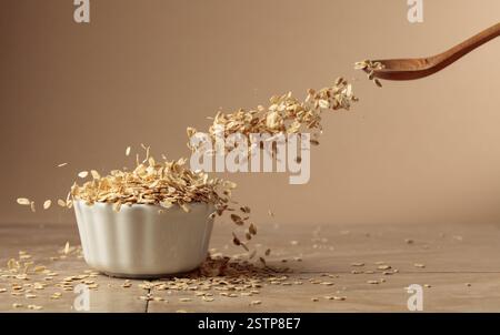 Oat flakes in motion on a beige background. Copy space Stock Photo - Alamy