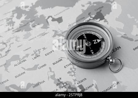 Compass on world map, toned in black-and-white Stock Photo - Alamy