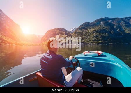Man controls a motorboat on a mountain lake Stock Photo - Alamy