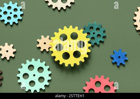 Wooden gears on green background Stock Photo - Alamy